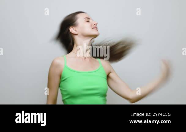 Fashion model looking at the camera, tossing her hair, looking ...