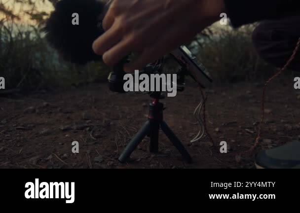 A young man enthusiastically captures various natural sounds outdoors ...