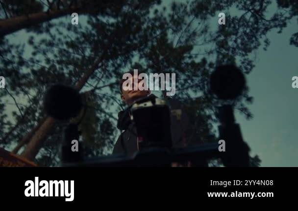 A young man enthusiastically captures various natural sounds outdoors ...