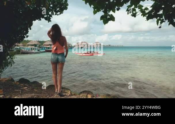 Young woman is enjoying the view of a luxury resort in bora bora, french polynesia. The ...