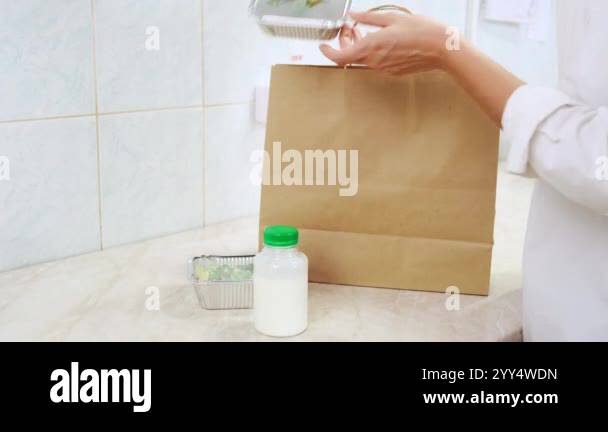 Woman pack ready meal lunch for clients. Delivery of balanced diet food ...
