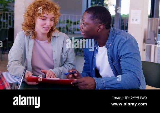 Students work together using a tablet in a modern outdoor setting ...