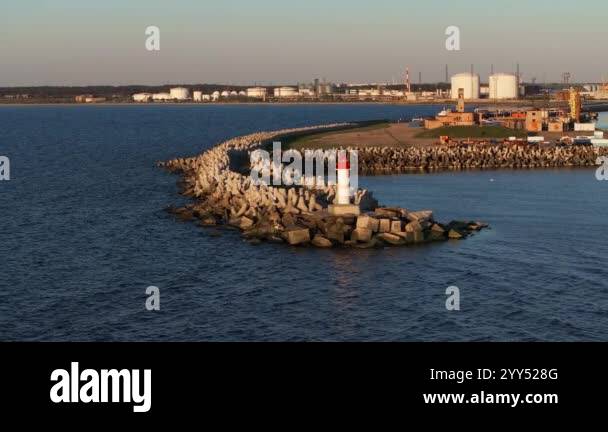 A breakwater with concrete tetrapods and a red topped lighthouse ...