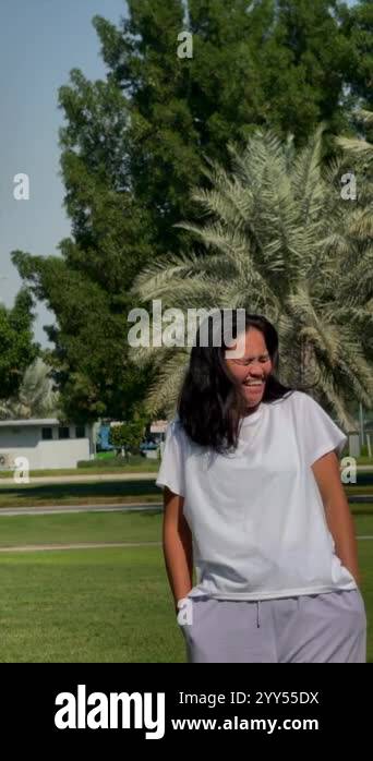 Woman laughing joyfully in sunlight, natural expression radiating ...