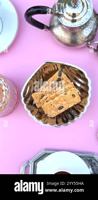Biscuits arranged elegantly in silver dish with polished tea cup, pink ...