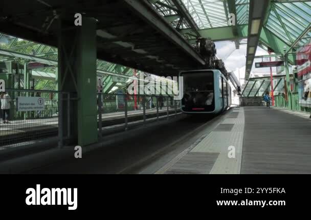 Suspension Railway station in Wuppertal with one train leaving and one ...