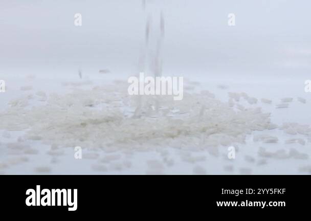 Rice falling in Slow Motion onto a white surface. Isolated on white ...