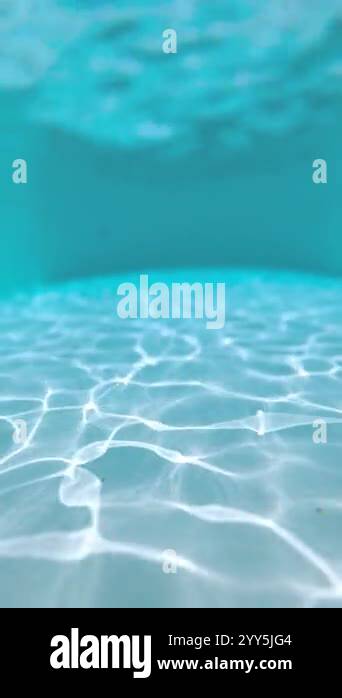 An underwater pool scene with clear blue water and sunlight creating ...