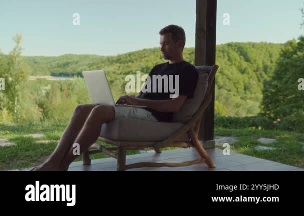 Freelancer works online and relaxes on the terrace of a country house ...
