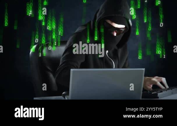 Hacker in hoodie using laptop over green binary code animation ...