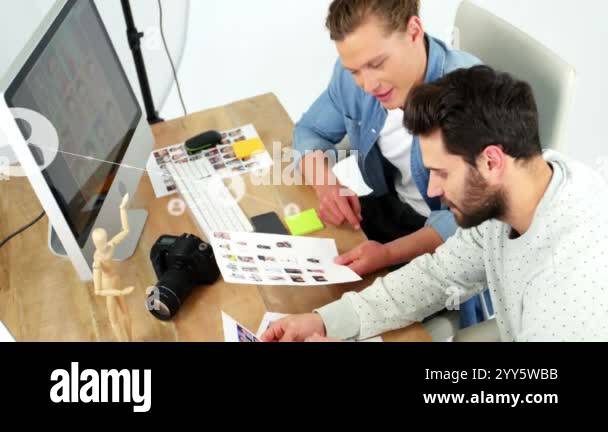 Collaborating on design project, two men at desk with social network ...