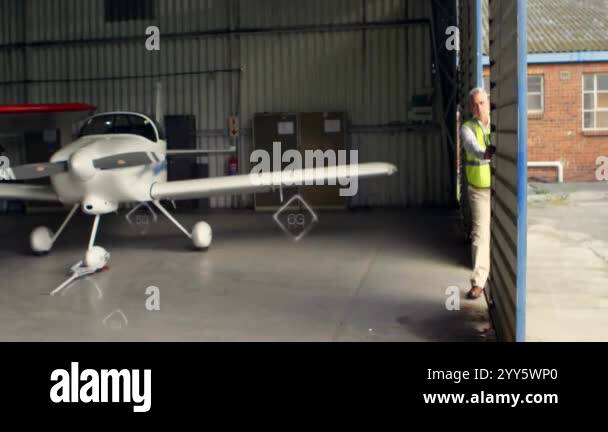 5G and 6G network symbols animation over man standing near small airplane in hangar. Technology ...
