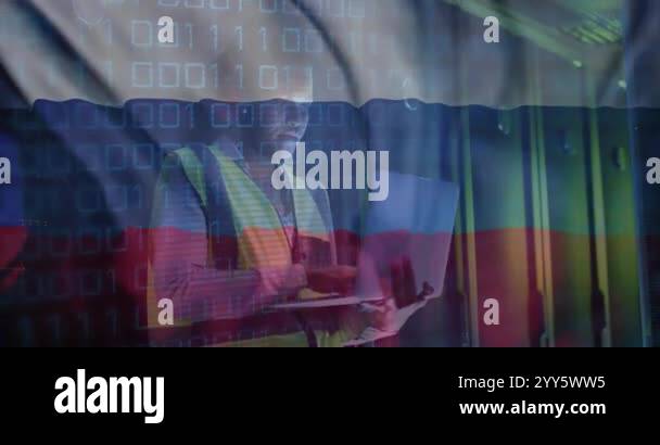 Binary code and flag animation over worker using laptop in industrial ...