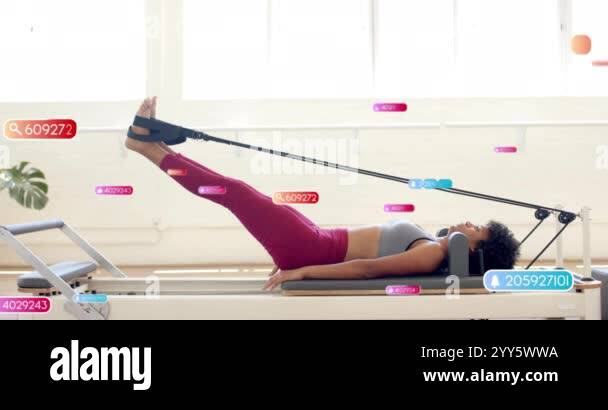 Exercising on Pilates reformer, woman with social media notifications ...