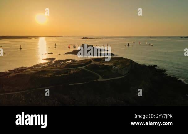 Aerial sunset view of a small island fort surrounded by the sea, with ...