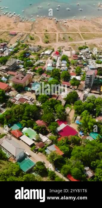Flying over the residential area, commercial buildings in Coron ...