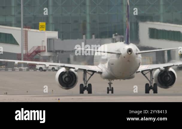 Passenger airplane taxiing to the runway, back view. Air traffic ...