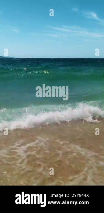 Azure surf breakers crash, leaving white sea foam on the sand ...