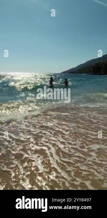 People are swimming in the sea, bouncing and swaying with the waves ...