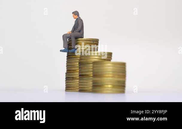 360-degree video of a miniature businessman figurine sitting atop a ...