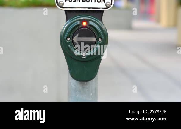 Detailed view of a pedestrian signal button being pressed, emphasizing ...