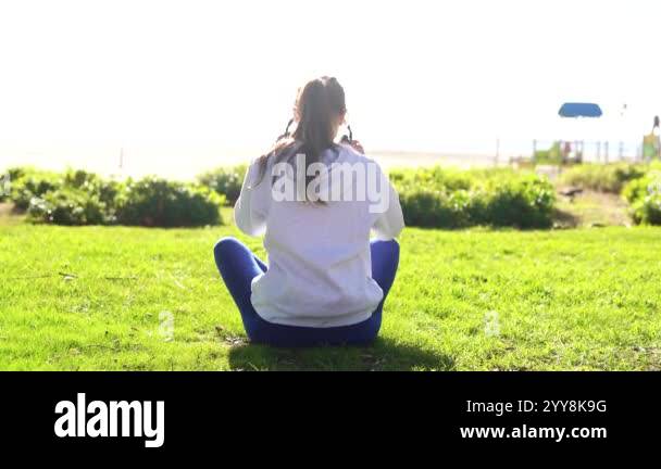 A woman in nature listens to music on headphones and relaxes Stock ...