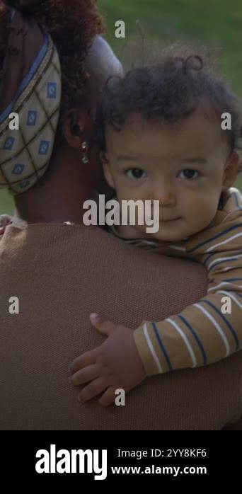 A small child rests peacefully on a parents shoulder, embraced by warm ...