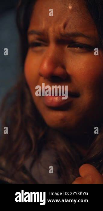 A closeup portrait of a woman illuminated by soft, low light, showing a ...