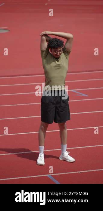 A young athlete is energetically stretching their muscles on a vibrant ...