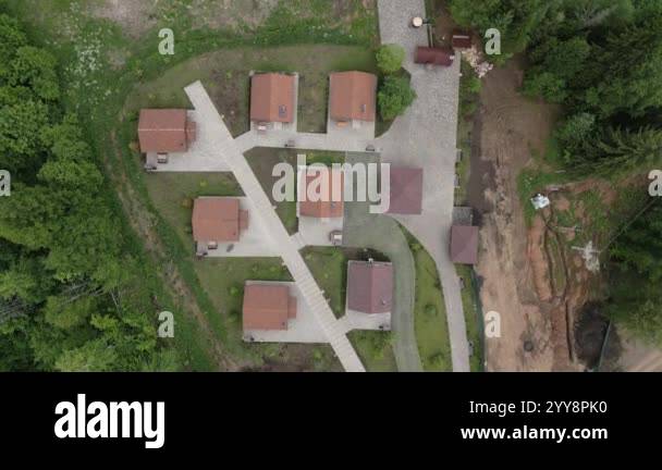 An aerial view captures charming cabins in lush greenery and winding ...