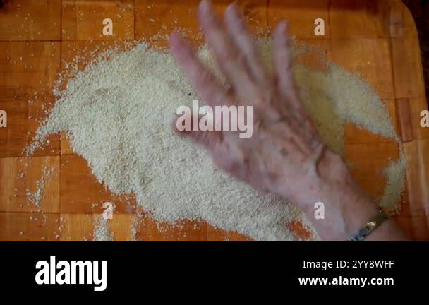 Process of breading a piece of meat with breadcrumbs by pounding the ...
