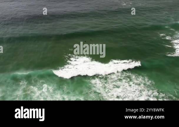 Drone footage capturing sweeping views of the ocean waves, emphasizing ...