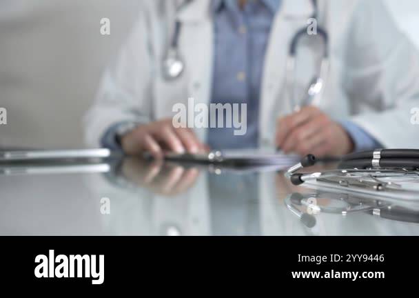 Stethoscope and medication history records form are on a glass table ...
