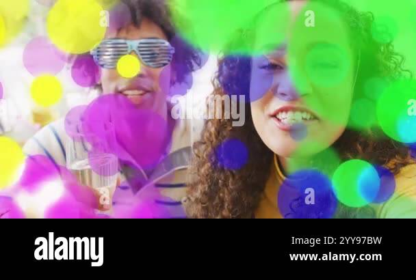 Celebrating with drinks, people enjoying colorful bokeh lights ...