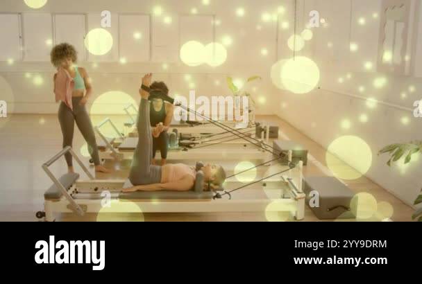 Exercising on Pilates reformers, people surrounded by glowing bubbles ...
