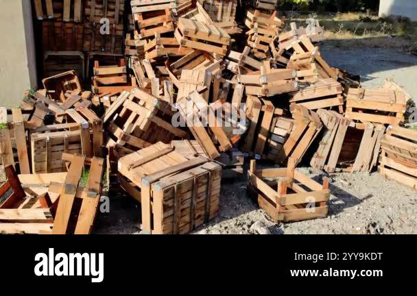 Stack of empty wooden crates leans against a wall outside a building ...