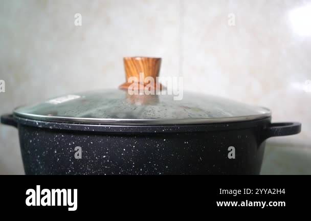 A traditional cooking pot with a fitted lid, resting neatly on a ...