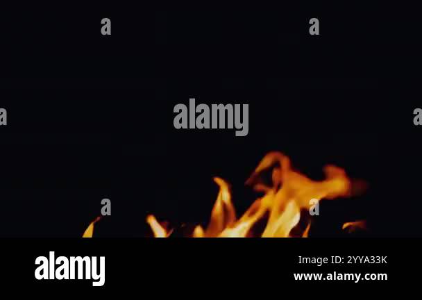 The vibrant fire flames are beautifully dancing in the darkness ...