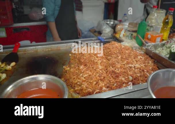 Carne al pastor cooking on a hot griddle, with golden tones that ...