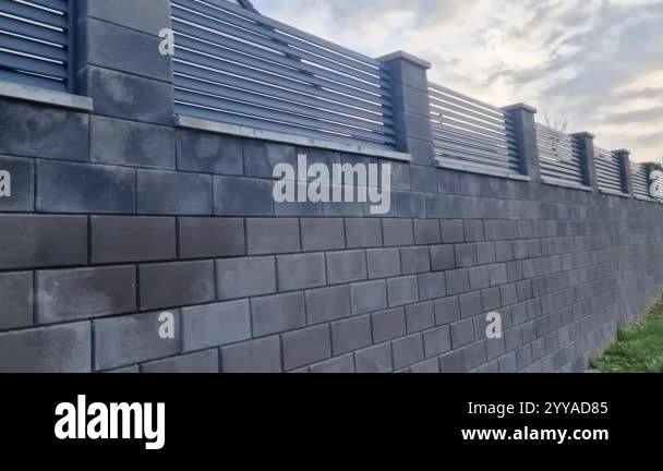 metal fillings of the fence with an underlay of concrete blocks. A ...