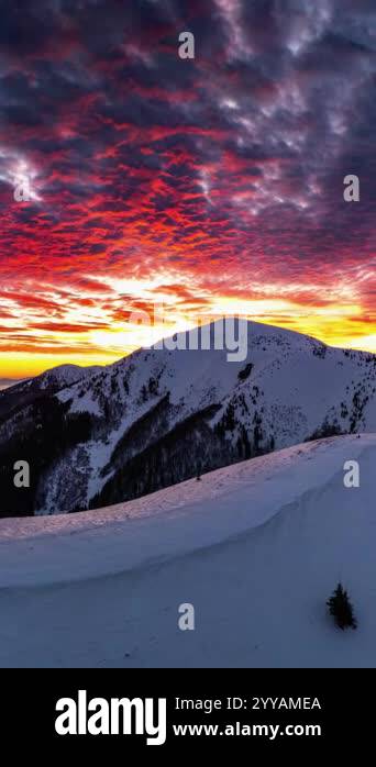 Colorful sunset with red clouds sky motion over frozen alps mountains ...