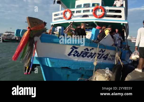 A Thai ferry is returning from a tour of a neighbouring island and ...
