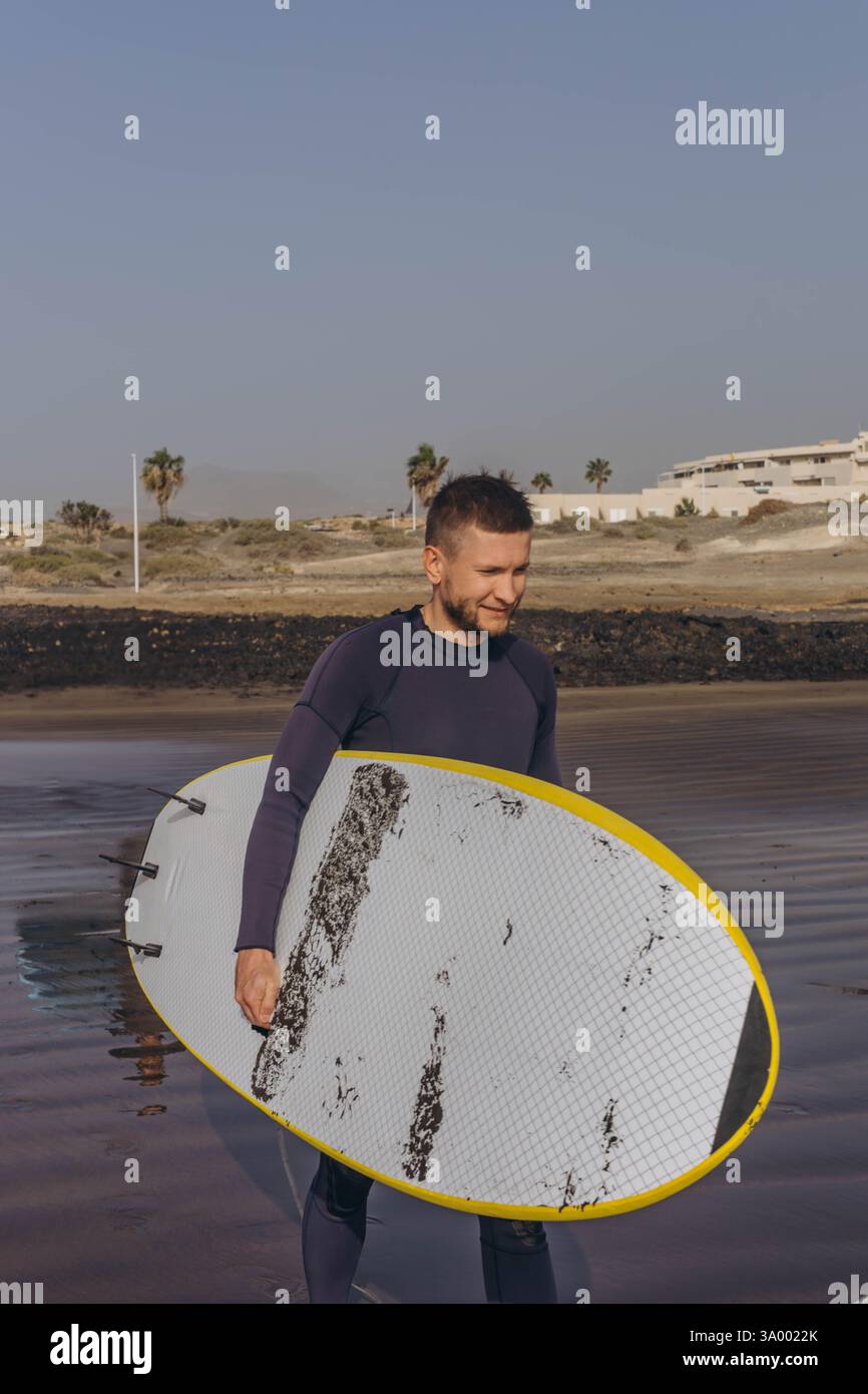 Portrait of a young male surfer in a wetsuit on the beach Stock Photo ...
