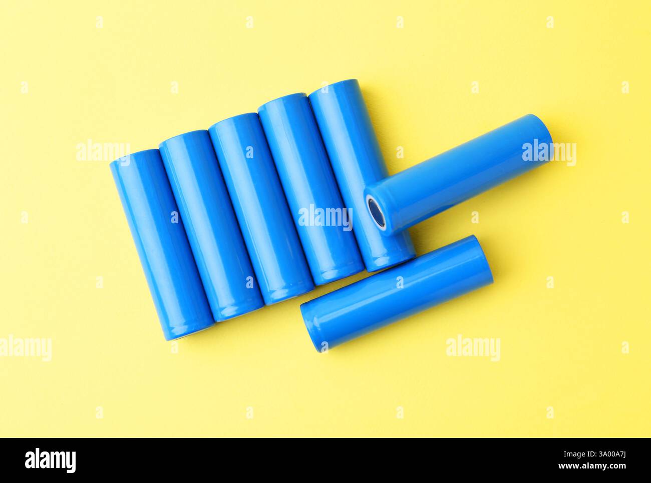 Many AA cell batteries on yellow background, top view Stock Photo - Alamy