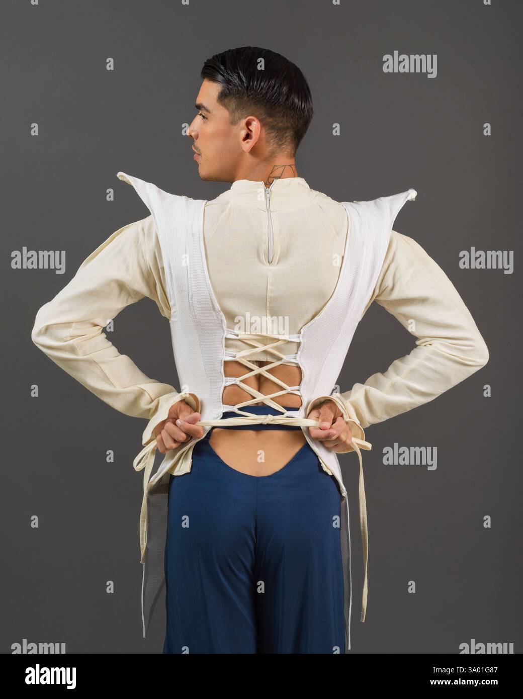 A man is shown from the back, wearing a unique, off-white, long-sleeved ...