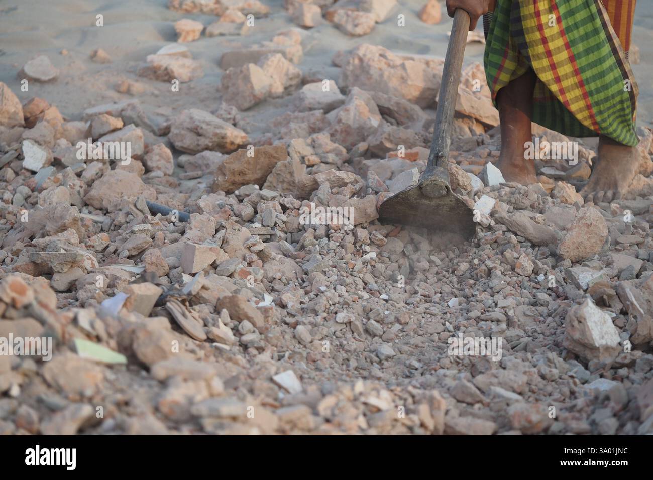 Construction worker clearing rubble at a site in daylight Stock Photo ...
