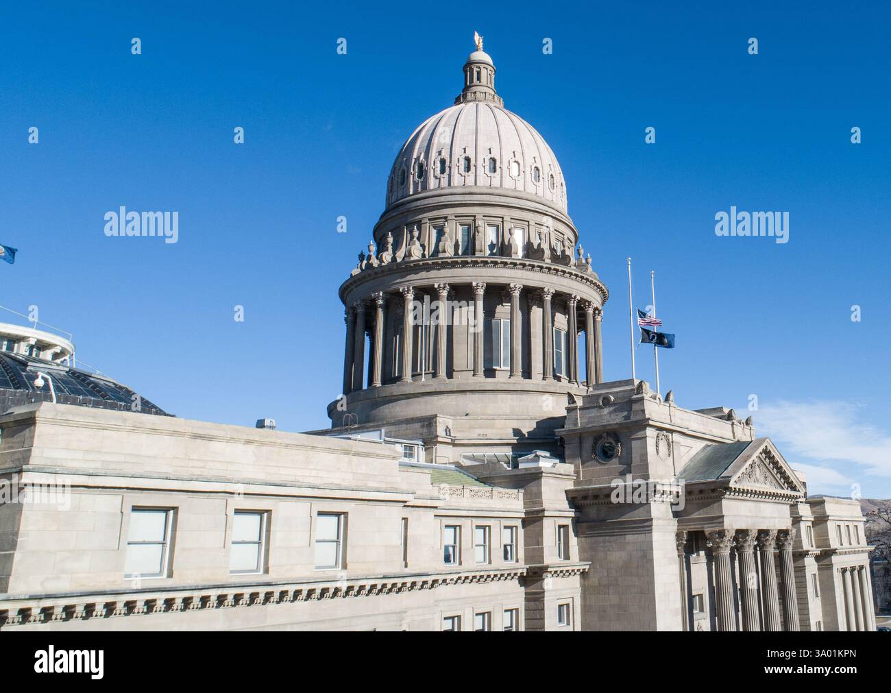 The Capitol building is a large, gray structure with a dome on top ...