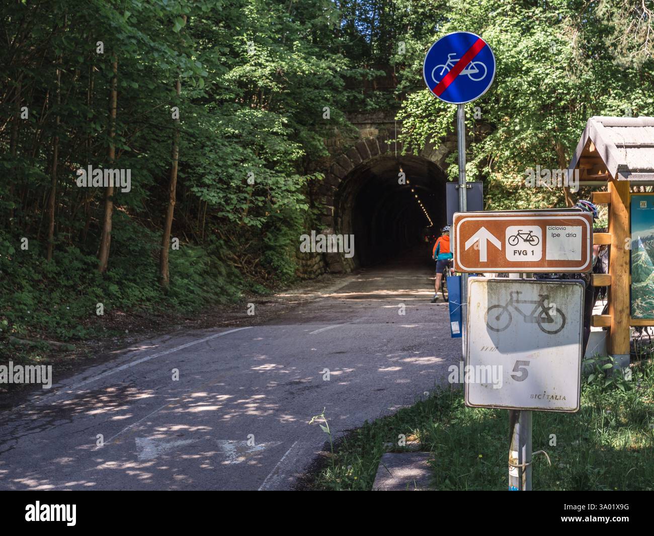 A cyclist rides into a historic railway tunnel on the Alpe Adria bike ...