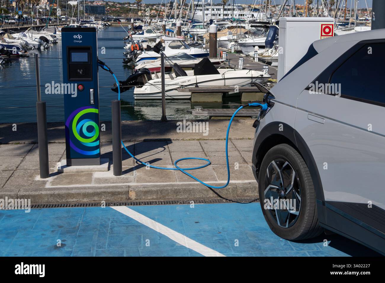 Modern electric car charging at a station by a marina, promoting ...