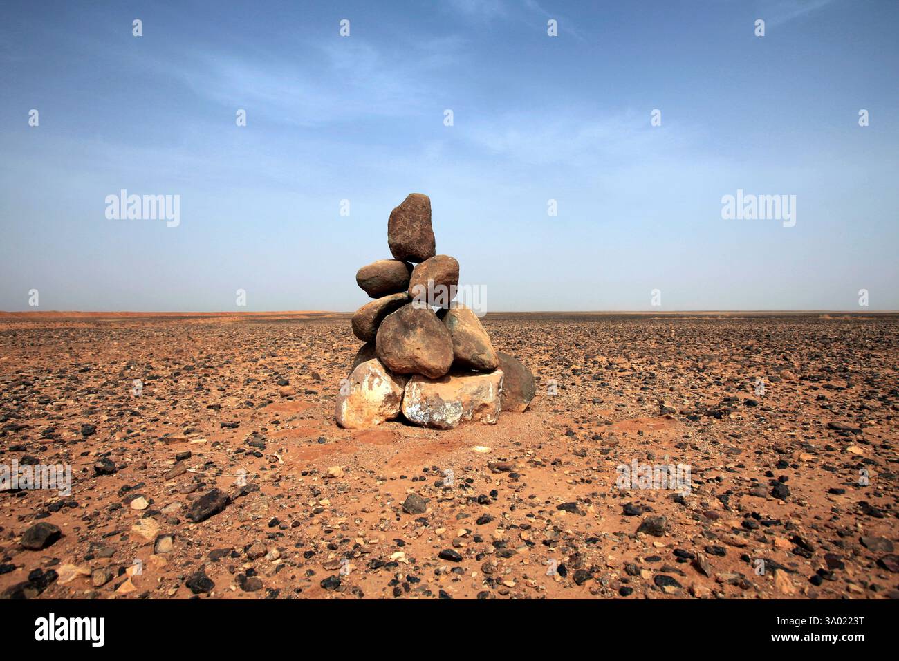 A small pyramid of basalt stones in the eastern desert of Jordan mark ...